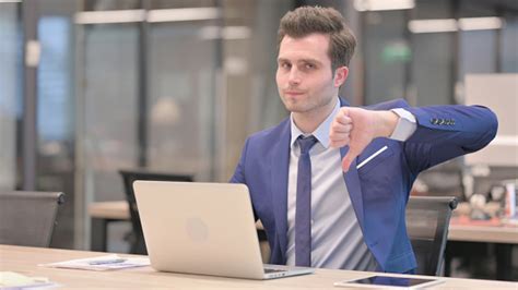 사무실에서 노트북을 사용하는 동안 엄지 손가락 아래로 기호를 보여주는 사업가 걱정하는에 대한 스톡 사진 및 기타 이미지 걱정하는 검색 공연 Istock