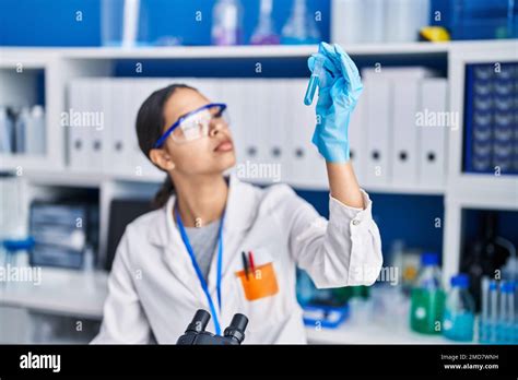 Young African American Woman Scientist Measuring Liquid At Laboratory