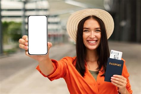 Premium Photo Cheerful Lady Passenger Displaying Smartphone Screen And Boarding Pass Outdoor