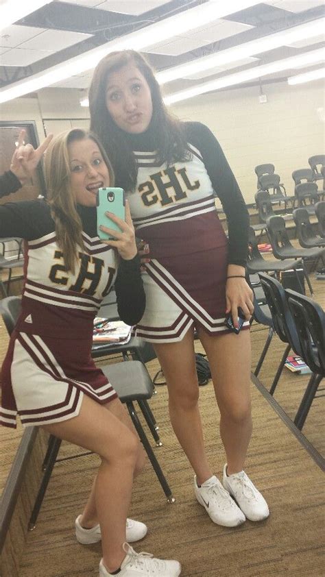 Two Cheerleaders Taking A Selfie With Their Cell Phone In The Middle Of
