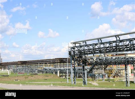 A Large Iron Metal Piping Trestle With Pipes And Electric Wires And Equipment At The