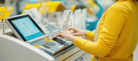 Female Cashier Working At Cash Register In Supermarket Stock