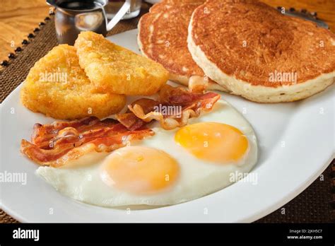 A Closeup Shot Of An American Breakfast With Pancakes Eggs Hash Brown