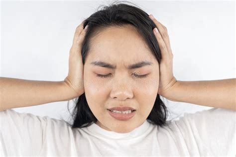 A Woman With Her Head Down And Her Hands On Her Ears Stock Image