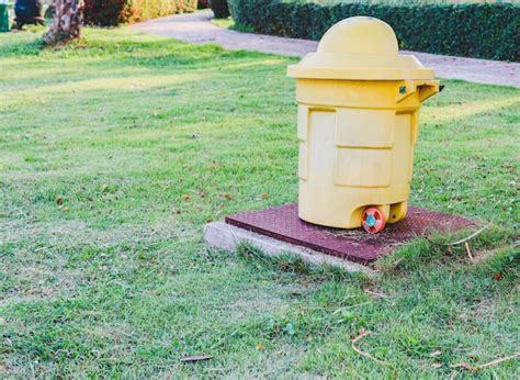 Premium Photo A Yellow Recycling Bin Placed On The Grass In The Park