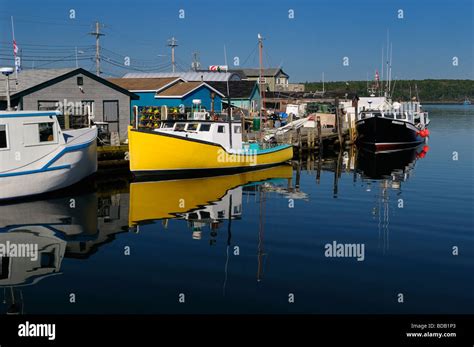 Fishing Boats And Lobster Traps Reflected In Blue Calm Water At