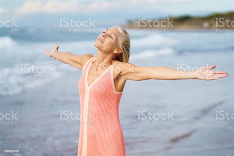 Beautiful Older Female Spreading Her Arms On A Beautiful Beach Spending