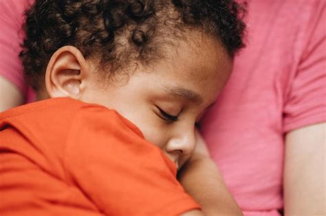 Menino Pré Escolar Dormindo No Peito Da Mãe Foto Premium