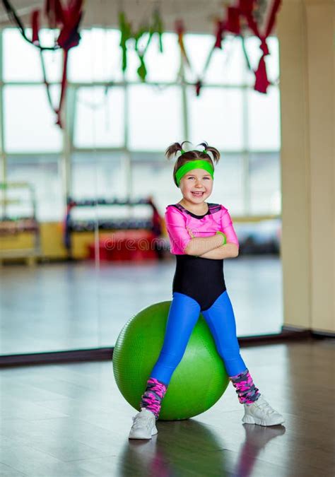 A Small Beautiful Girl In Athletic Form Trains In The Gym With A