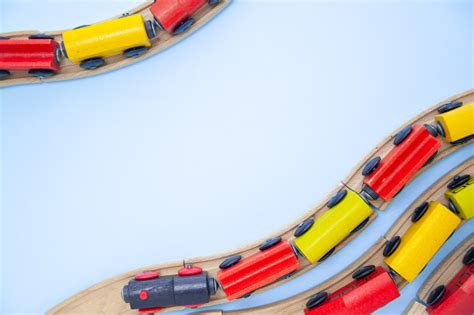 파란색 배경에 나무 철도에 여러 가지 빛깔의 아이 기차 자동차 벽돌로 만든 텍스트 프레임 복사 합니다 평면도 평평한 누워 테이블에 어린이 장난감 0명에 대한 스톡 사진 및