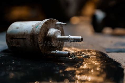 Rusty Fuel Filter On A Dark Garage Floor With Oil Puddle Stock Image Image Of Automotive