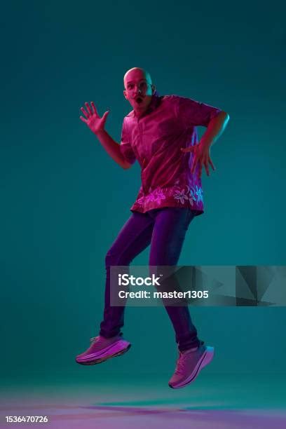 Potret Fulllength Pria Botak Muda Dengan Kumis Dalam Pakaian Bergaya Melompat Secara Emosional