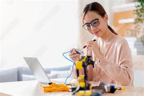 smart asian female programer learning robot arm ai coding electronic