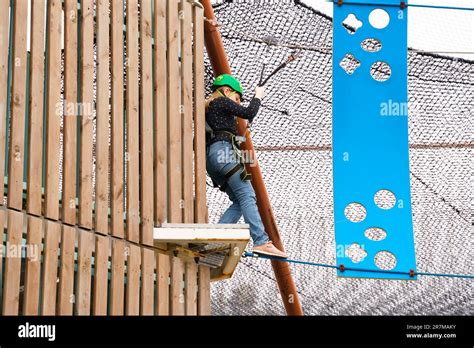 Teenage Teen Girl In Climbing Harness Equipment Green Sports Safety Helmet Rope Amusement Park