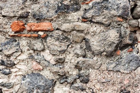 Texture Of A Stone Wall Of An Old Building With Crumbling Plaster
