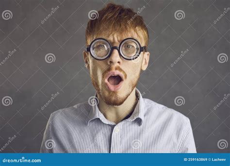 Studio Headshot Portrait Of Shocked Young Man In Funny Round Glasses