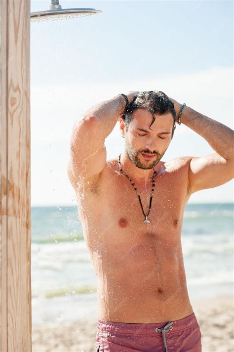 Premium Photo Handsome Topless Man Taking A Shower On The Beach
