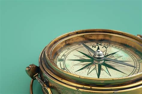 A Gold Compass With A Black Face Sits On A Tan Surface Premium Ai