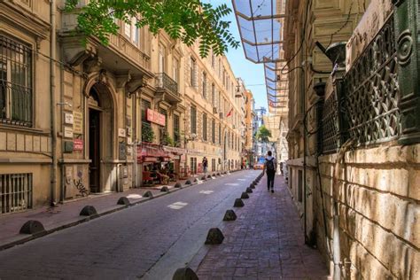Sunny Street Scene With Historic Architecture And Pedestrian In Urban