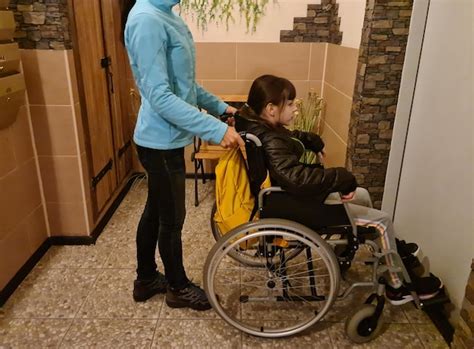Premium Photo Woman Pushes Disabled Sister In Wheelchair And Door Of