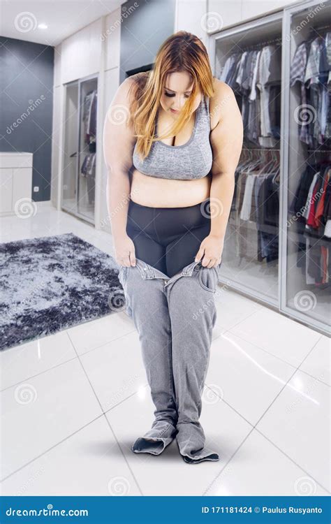 Menina Sobrecarregada Tentando Usar Jeans Apertados Foto De Stock