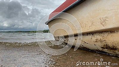A Boat Anchored In Harbor Dock Near The Water And Waves Lapping Up