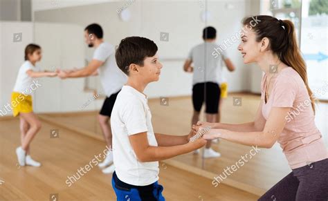 Cheerful Young Woman Practicing Active Dance In Pair With Her Tween Son