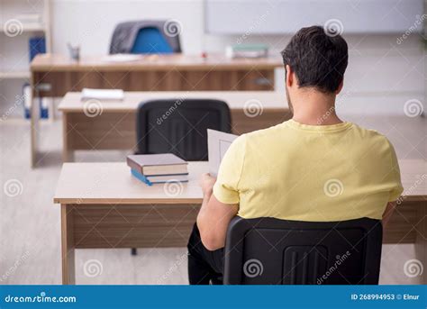 Joven Profesor De Sexo Masculino Sentado En El Aula Imagen De Archivo Imagen De Diligente