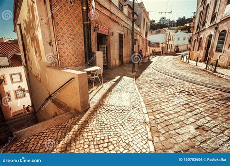 Sunny Cobbled Streets With Tram Rails And Small Shops Of Historical