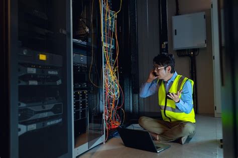 Premium Photo Asian Male Engineer With Laptop Talking On Smartphone