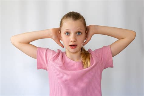 Surprised Girl With Hands Behind Head Indoors Portrait Of A Young Girl