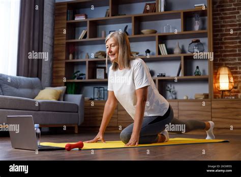 Gray Haired Happy Mature Woman Doing Gymnastics And Yoga At Home Online