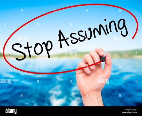 Man Hand Writing Stop Assuming With Black Marker On Visual Screen