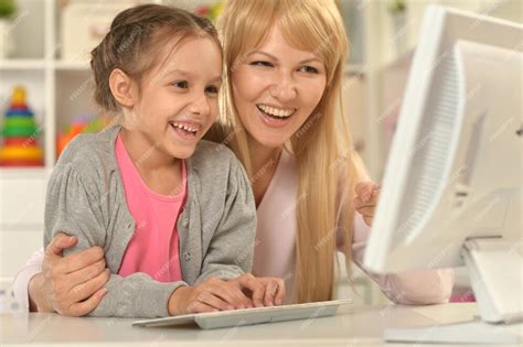 Premium Photo Portrait Of Mother And Daughter Using Computer