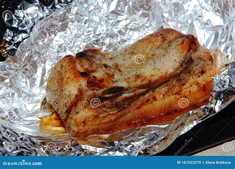 Baked Piece Of Pork Meat On Aluminum Foil The Process Of Cooking Meat