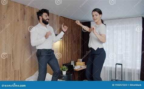 Joyful Young People Husband And Wife Dancing On Hotel Bed Undressing