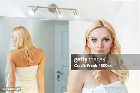Blond Woman In A White Bathroom Looking At The Camera Wearing A Towel