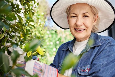 Premium Photo Happy And Mature Woman Gardening And Flower Inspection