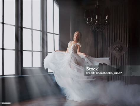 공정한 피부와 금발 머리를 가진 달 콤 하 고 부드러운 소녀는 오래 된 성에 서 침묵에 혼자 버려진 중세 건물의 정신은 태양 광선에 흰색 연기와 마법의 두꺼운 안개에