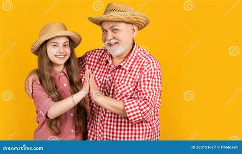 Chica Feliz Con Abuelo Con Sombrero De Paja De Fondo Amarillo Imagen De Archivo Imagen De