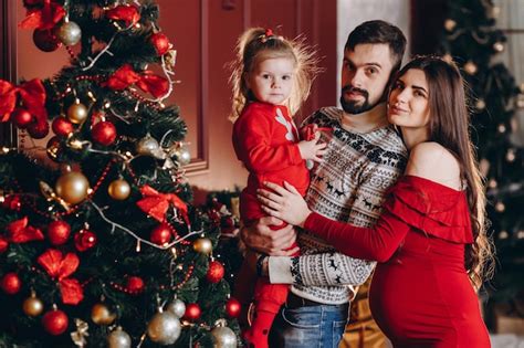 Mamá Papá E Hija En El Fondo De Un árbol De Navidad Foto Premium