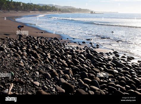 Large Rocks On The North End Of El Tunco Beach As A Runner Rests In El