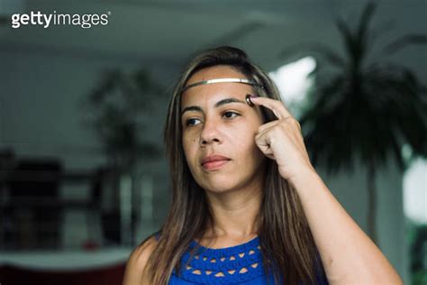 Woman Initializing A Futuristic Measuring Device On Her Head 이미지