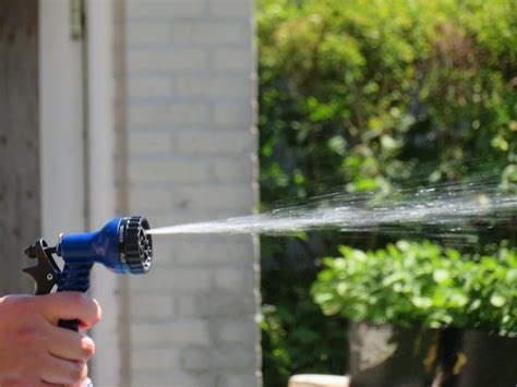 Premium Photo Cropped Hand Holding Squirt Gun Spraying Water