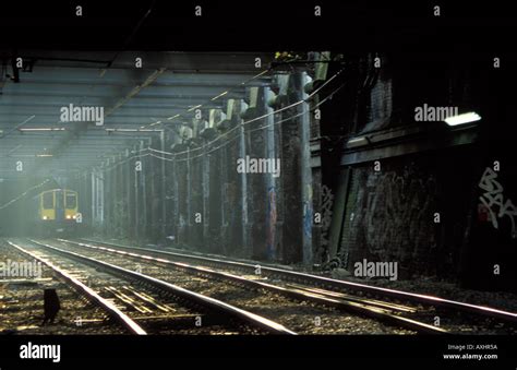London Underground Train Passing At High Speed Under A Bridge Through A