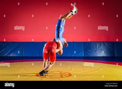 Two Greco Roman Wrestlers In Red And Blue Uniform Wrestling On A Yellow