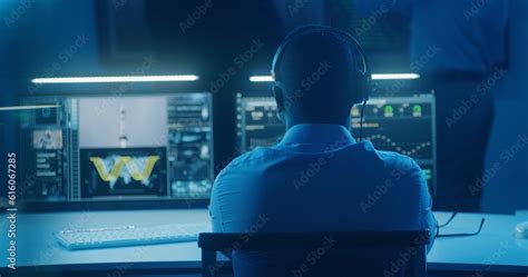 African American Flight Control Employee Sits In Front Of Computers Monitors Space Mission In
