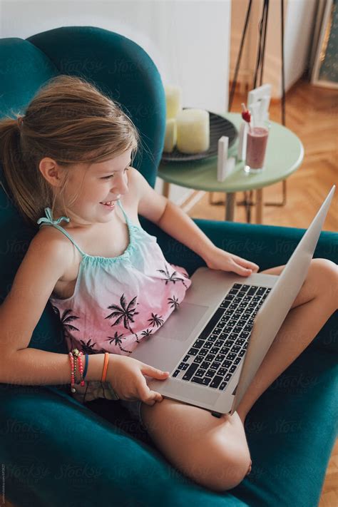 Blonde Girl Watching Something On A Laptop Computer By Stocksy