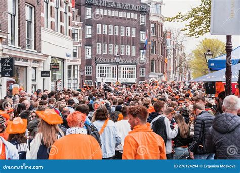 People In Orange Clothing Are Sailing In A Boat On The Canals Of
