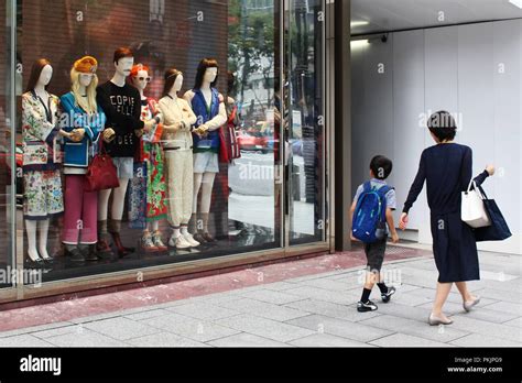 Passing Pedestrians Look At A Gucci Stores Striking Window Display